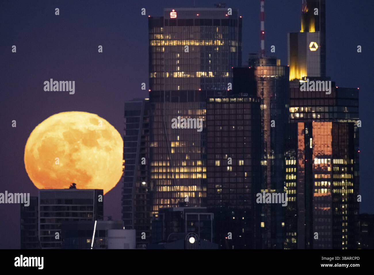 The full moon passes behind the Frankfurt banking skyline, Frankfurt am ...