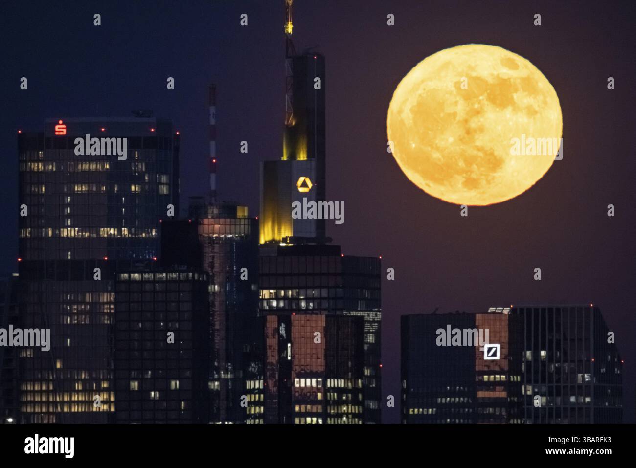 The full moon passes behind the Frankfurt banking skyline, Frankfurt am ...