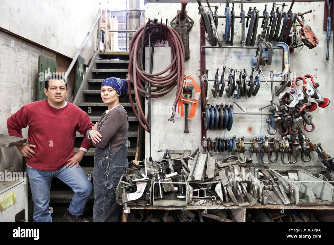 Hispanic male and Black, Asian female worker standing near tools in ...