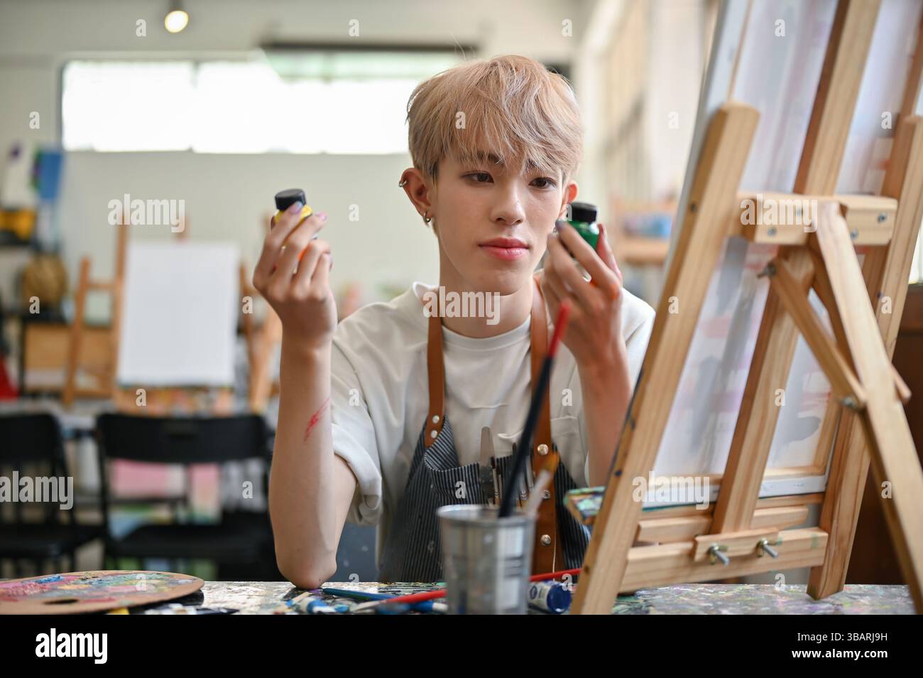 A creative and talented young Asian gay male artist or painter chooses ...