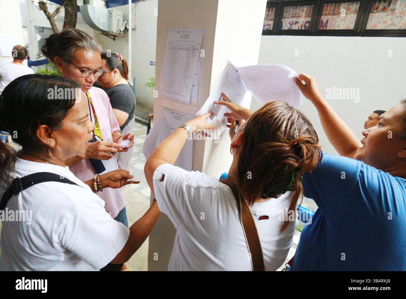 Philippines. 12th May, 2025. Voters check their name on voter's ...