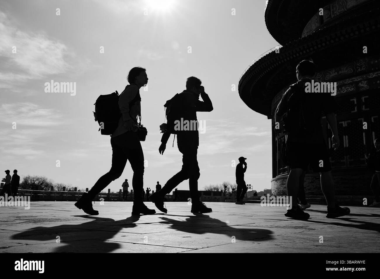 Two figures in the foreground walk with purpose as smaller silhouettes ...