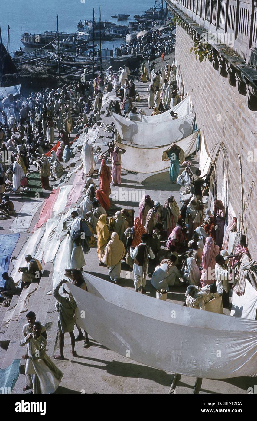 1960s, historical, people beside the Ganges river gathered to pray and ...