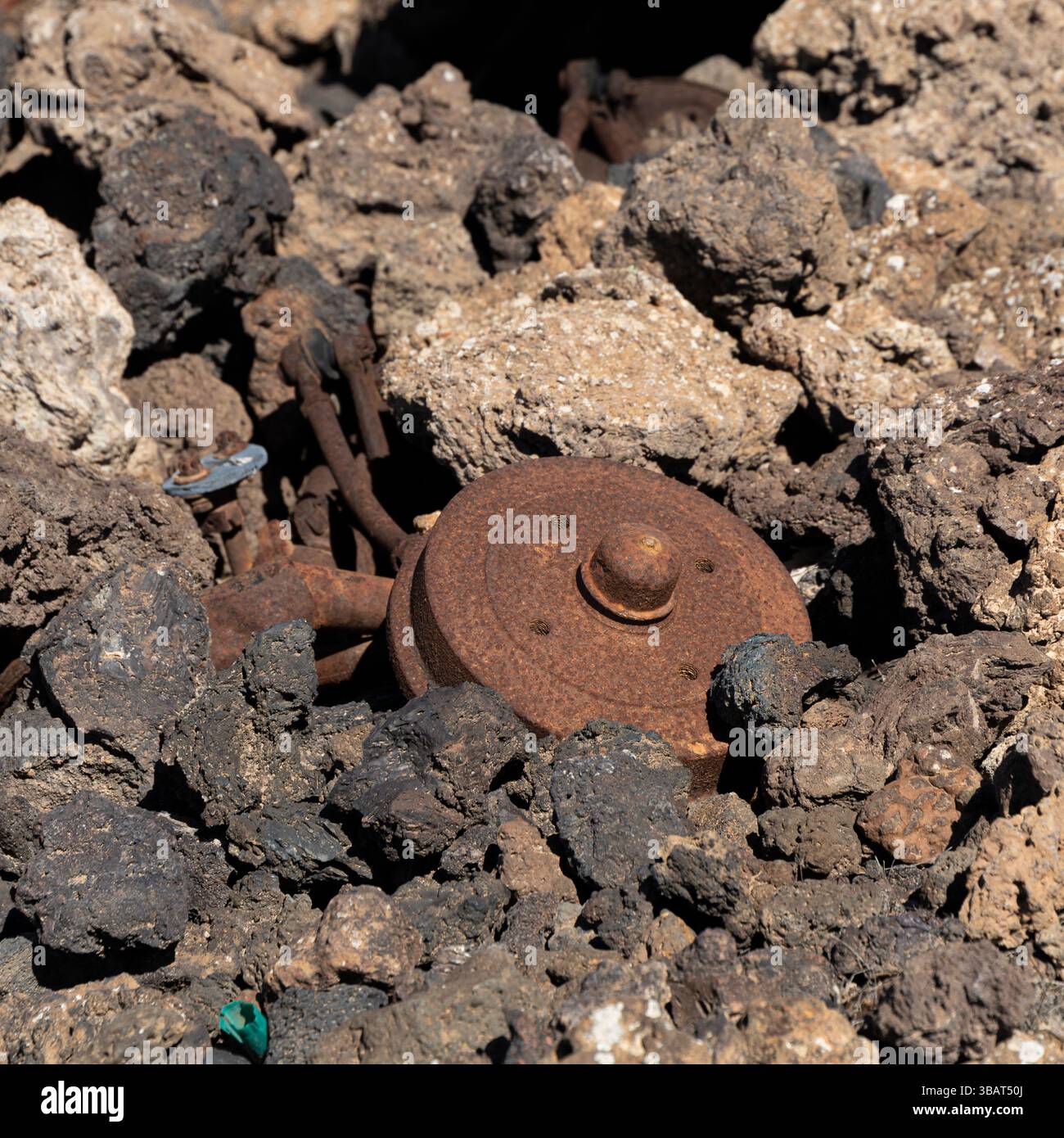 Rusted parts of a car's suspension and wheel hub lie in a lava field on ...