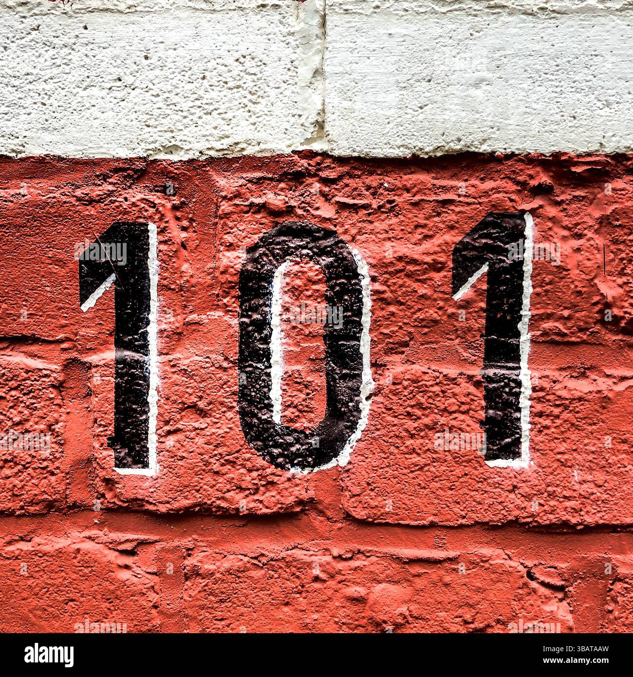 House number 101 painted black with white shading on red brickwork ...