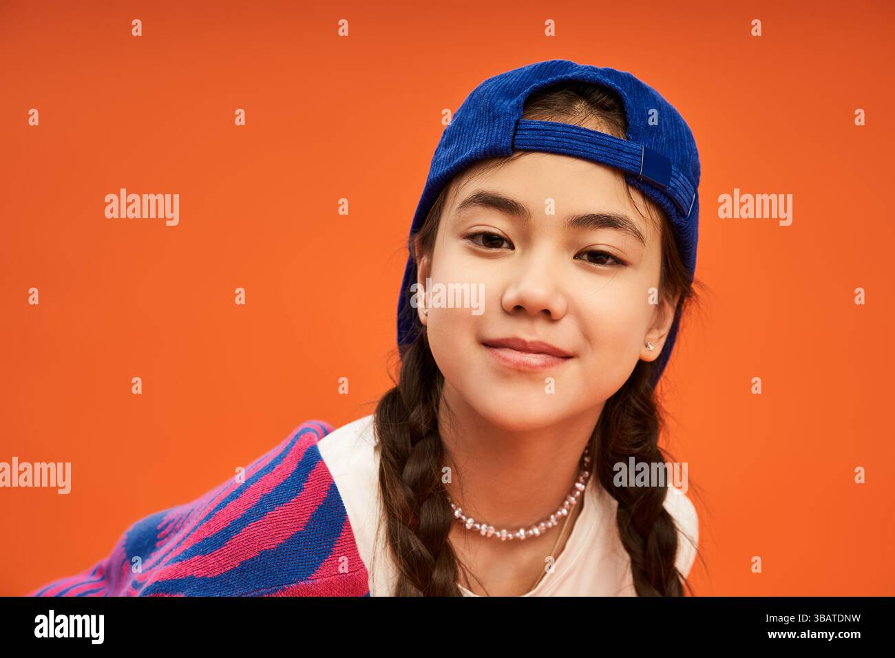 A confident asian girl poses in an eye-catching outfit against a bold ...