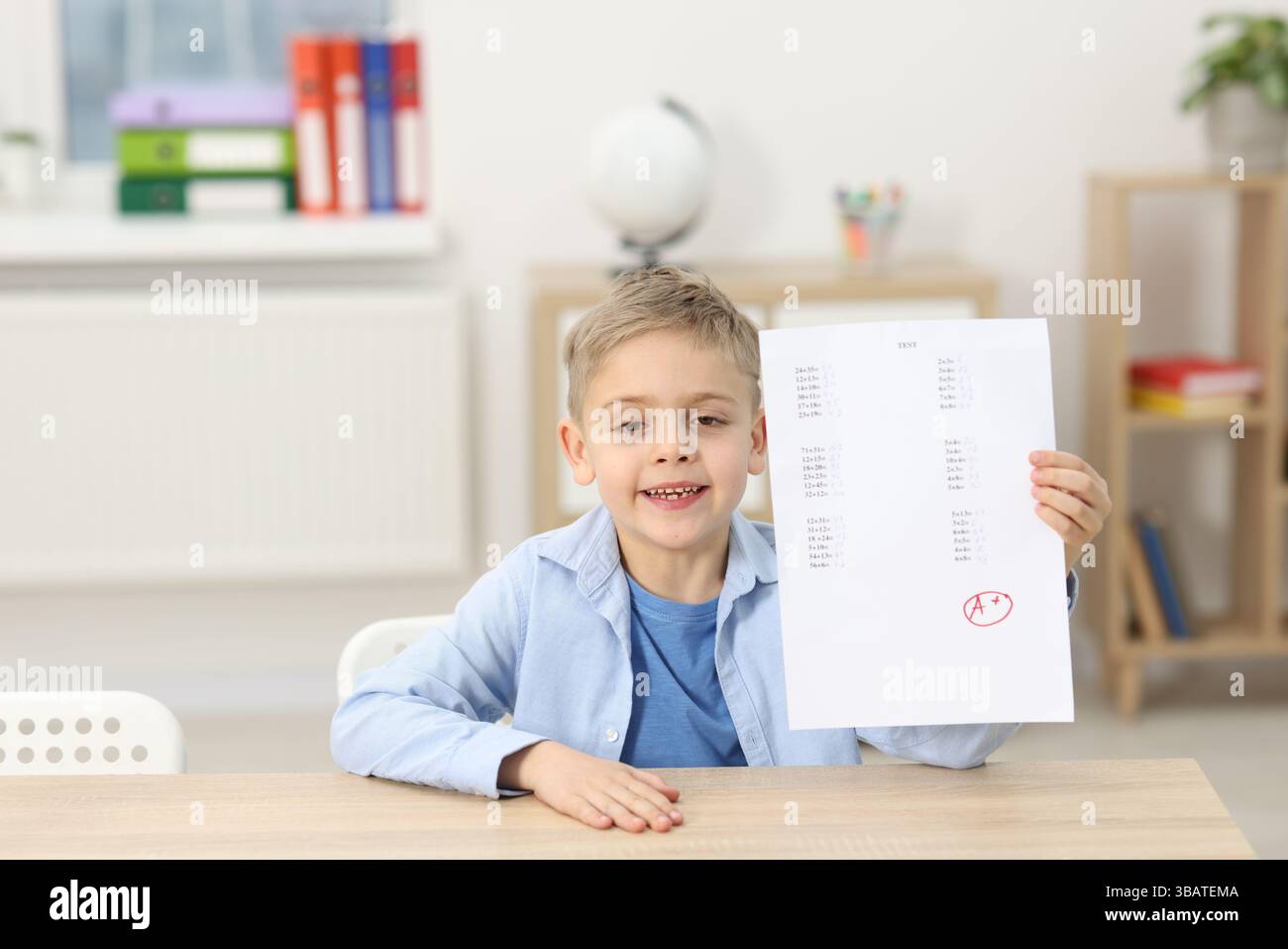 School grade. Happy boy holding answer sheet with letter A and plus ...