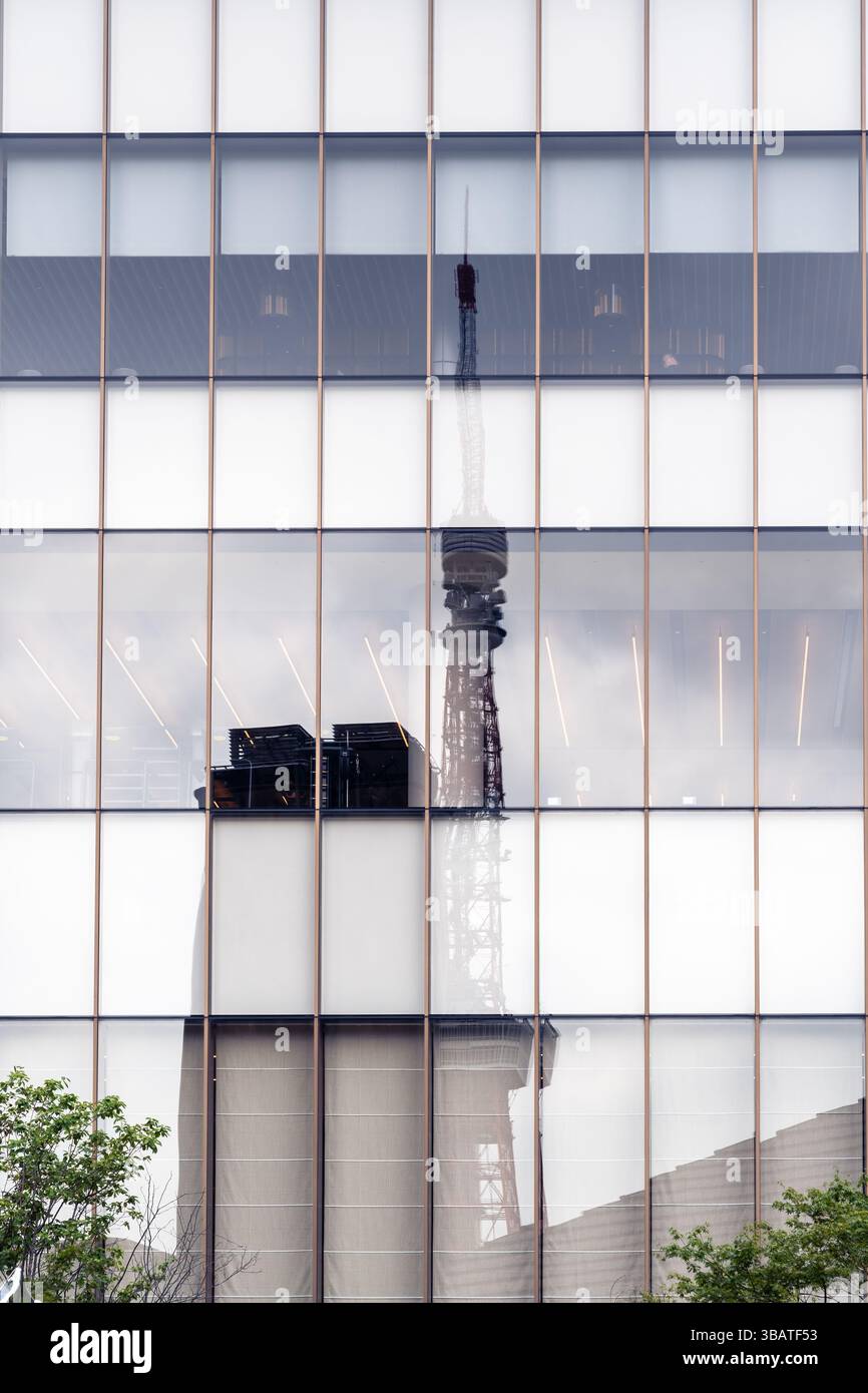 Tokyo, Japan-august 6, 2024:The famous Tokyo Tower is reflected in the glass windows of Azabudai ...