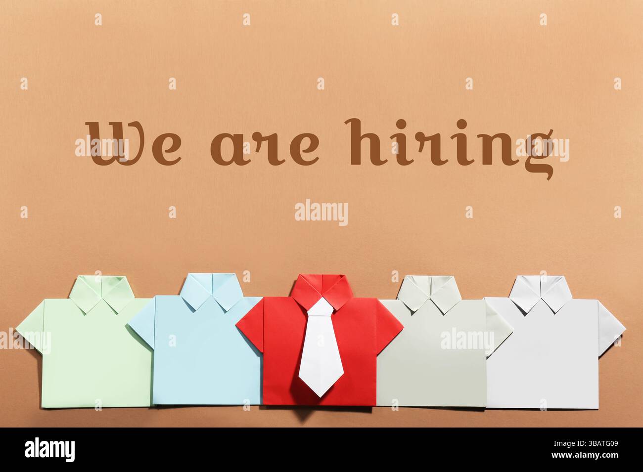 We Are Hiring. Many paper shirts on brown background, flat lay ...