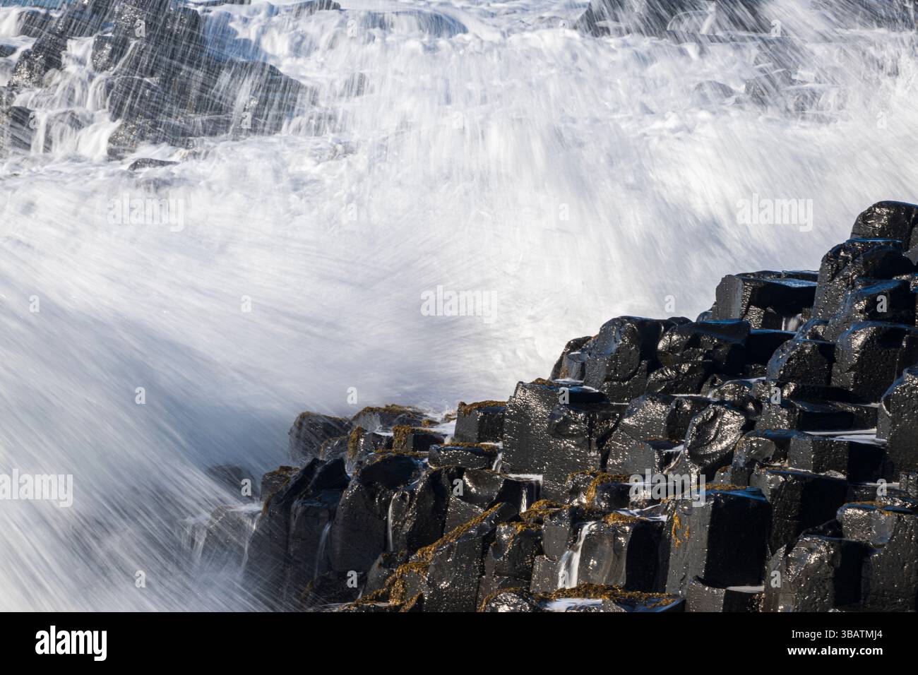 Close up of waves breaking on interlocking basalt columns of Grand Causeway, Giant's Causeway ...