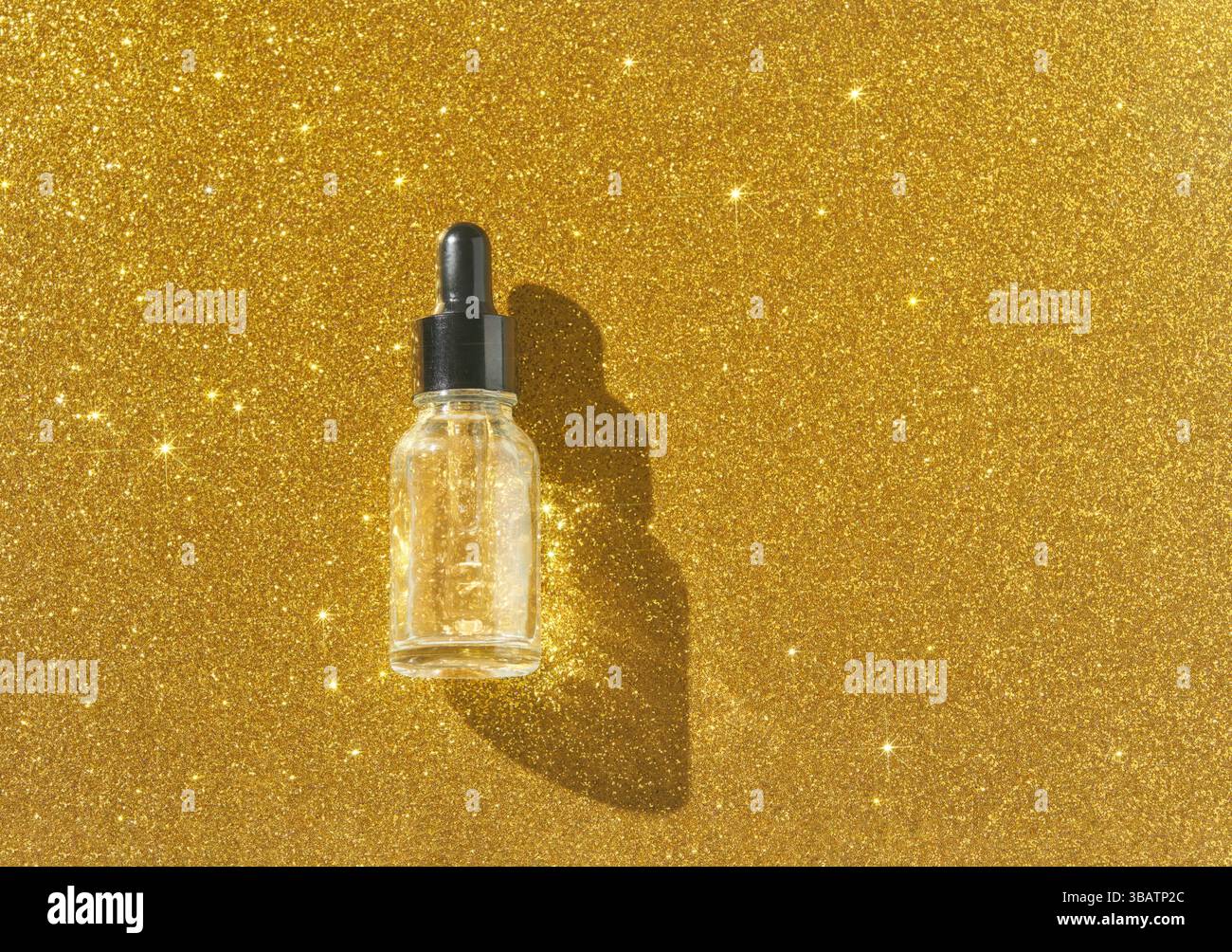Transparent dropper bottle on sparkling gold background with shimmering ...