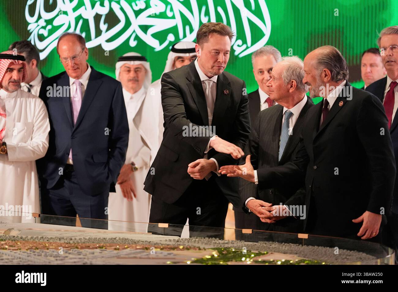 Elon Musk, center, shakes hands with Secretary of Commerce Howard ...