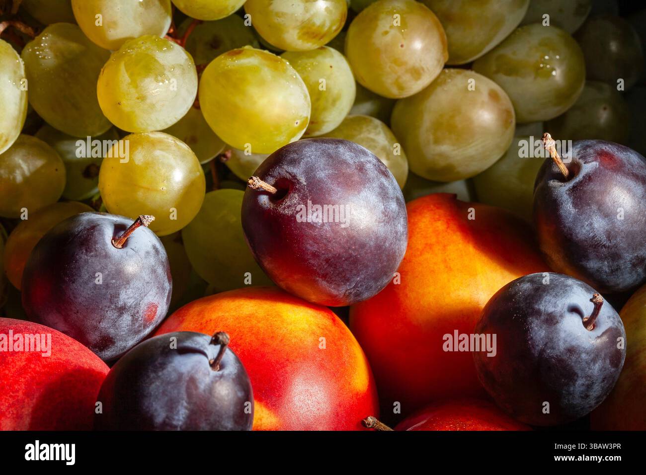 plum fruit mix on black background Stock Photo - Alamy