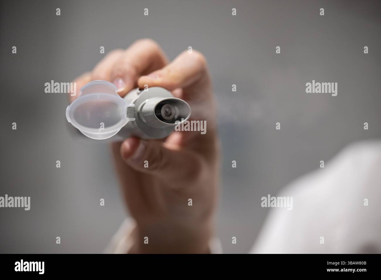 PRODUCTION - 09 May 2025, Berlin: A pharmacist demonstrates an inhaler ...