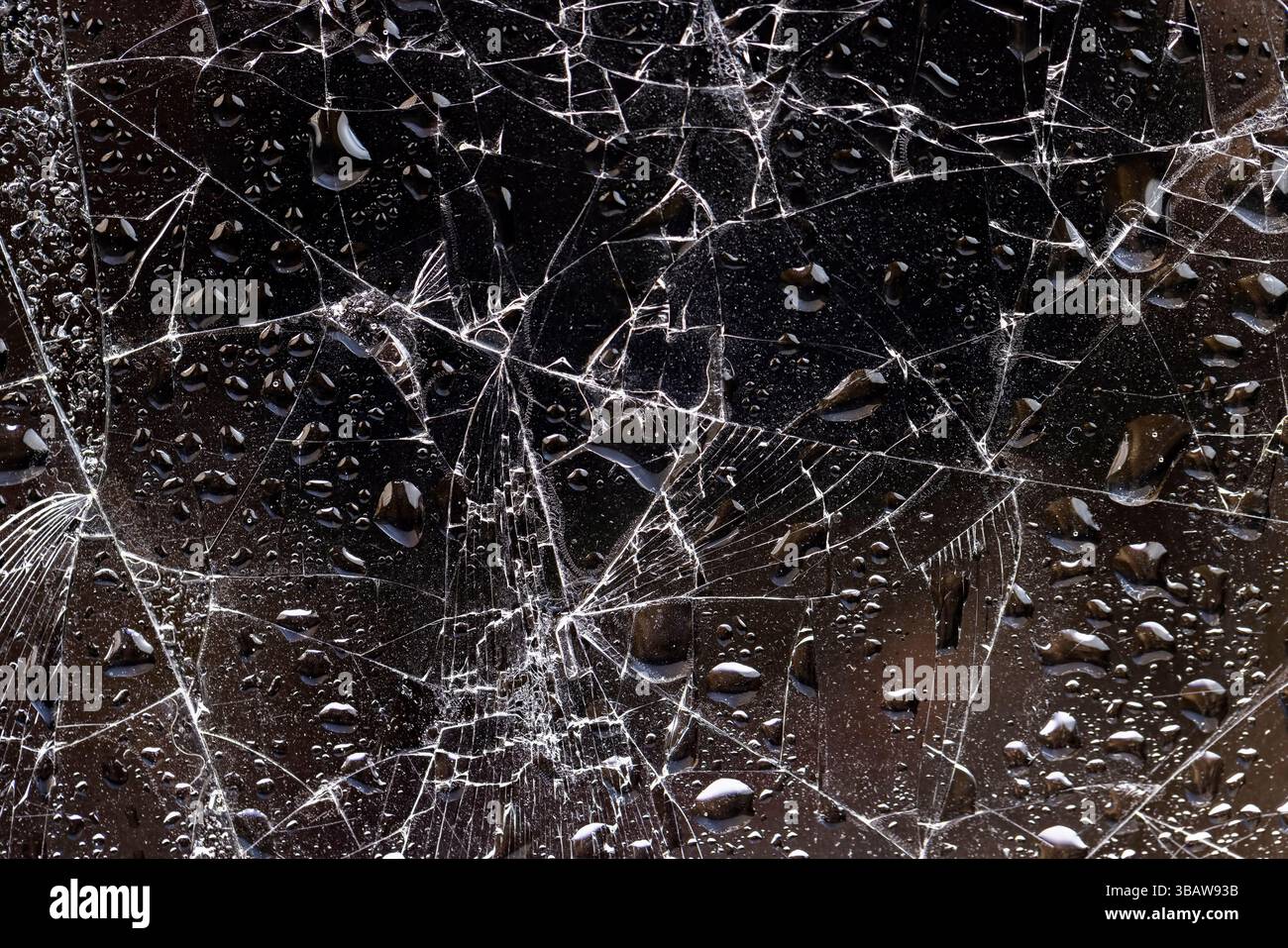 water covered broken glass with a lot of damage on a black background ...