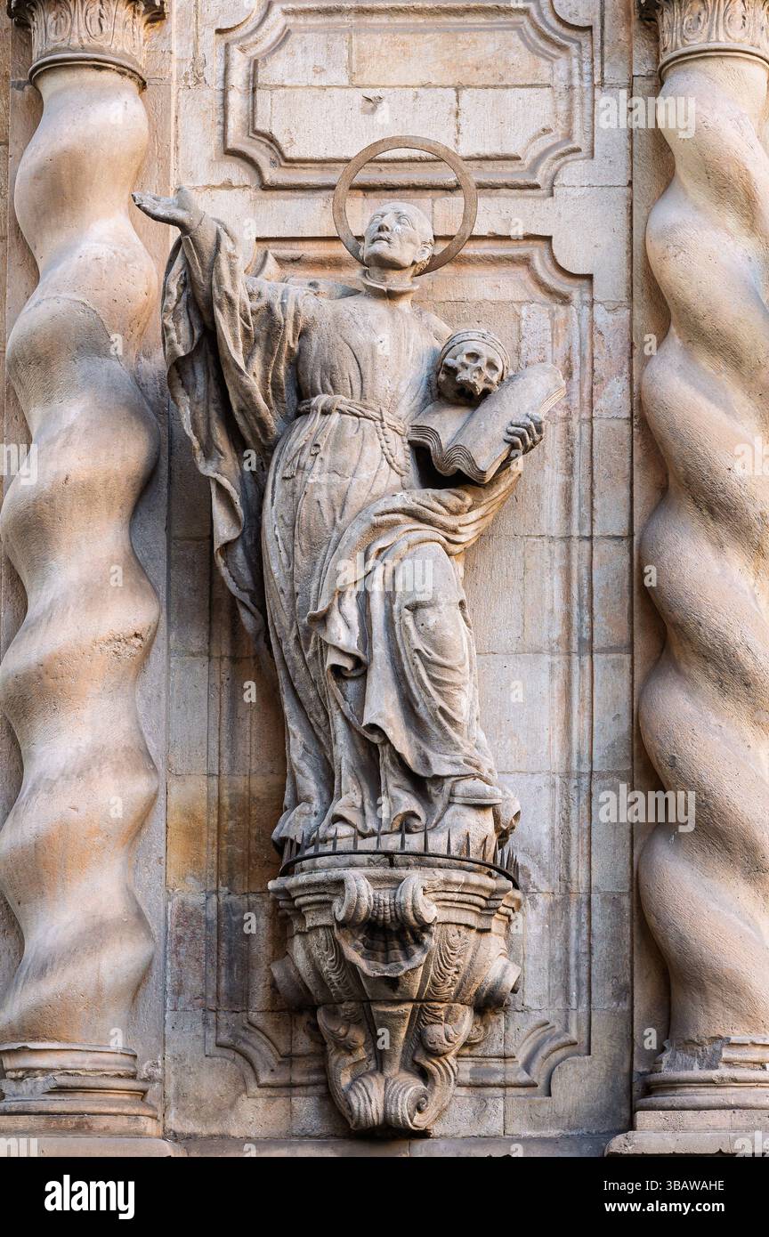 Ancient weathered religious sculpture of saint holding skull and book ...