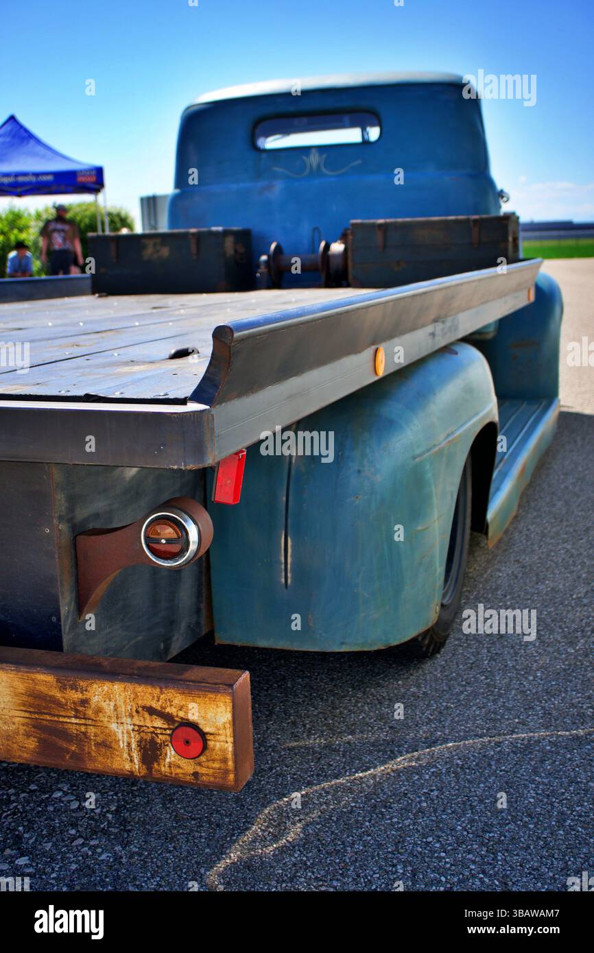 Rear view of a vintage blue flatbed pickup truck with rustic wooden ...