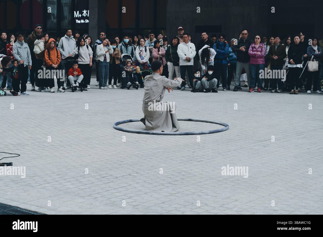 Performer captivates a crowd outside M+ museum with a slow, meditative ...