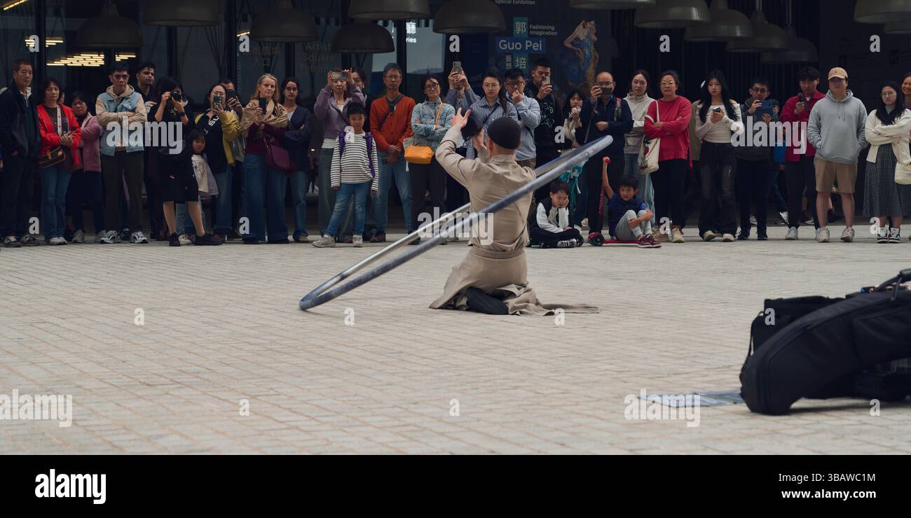 Crowd watches in awe as a street performer interacts with a spinning ...