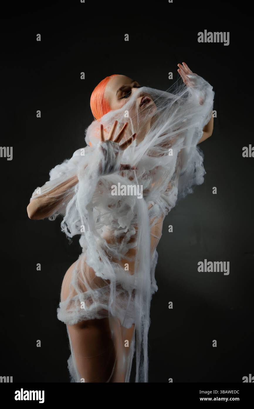 Red woman entangled in delicate net trap revealing beauty and struggle ...