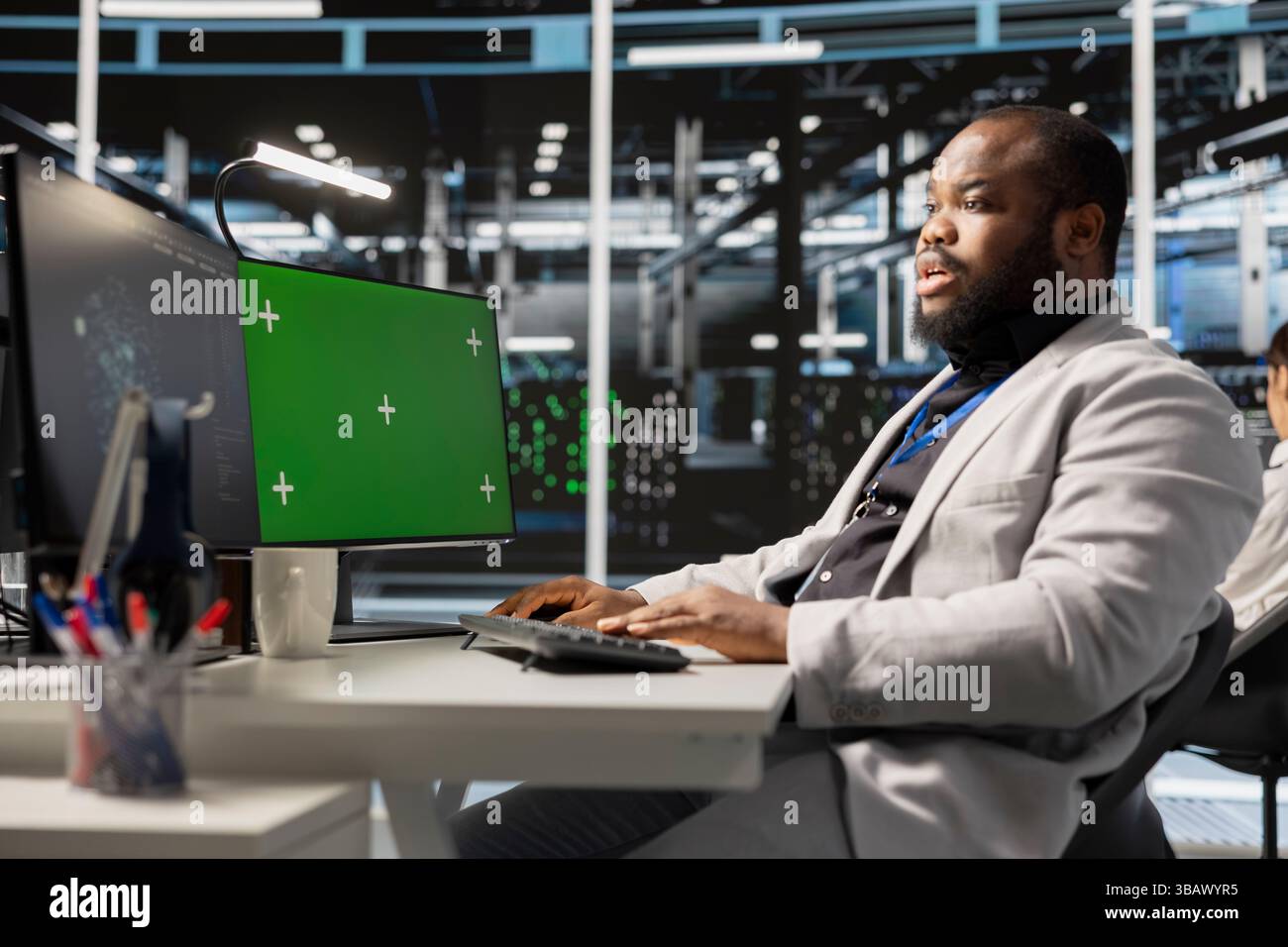 Data center technician inspecting gear using green screen mockup PC, doing maintenance tasks ...