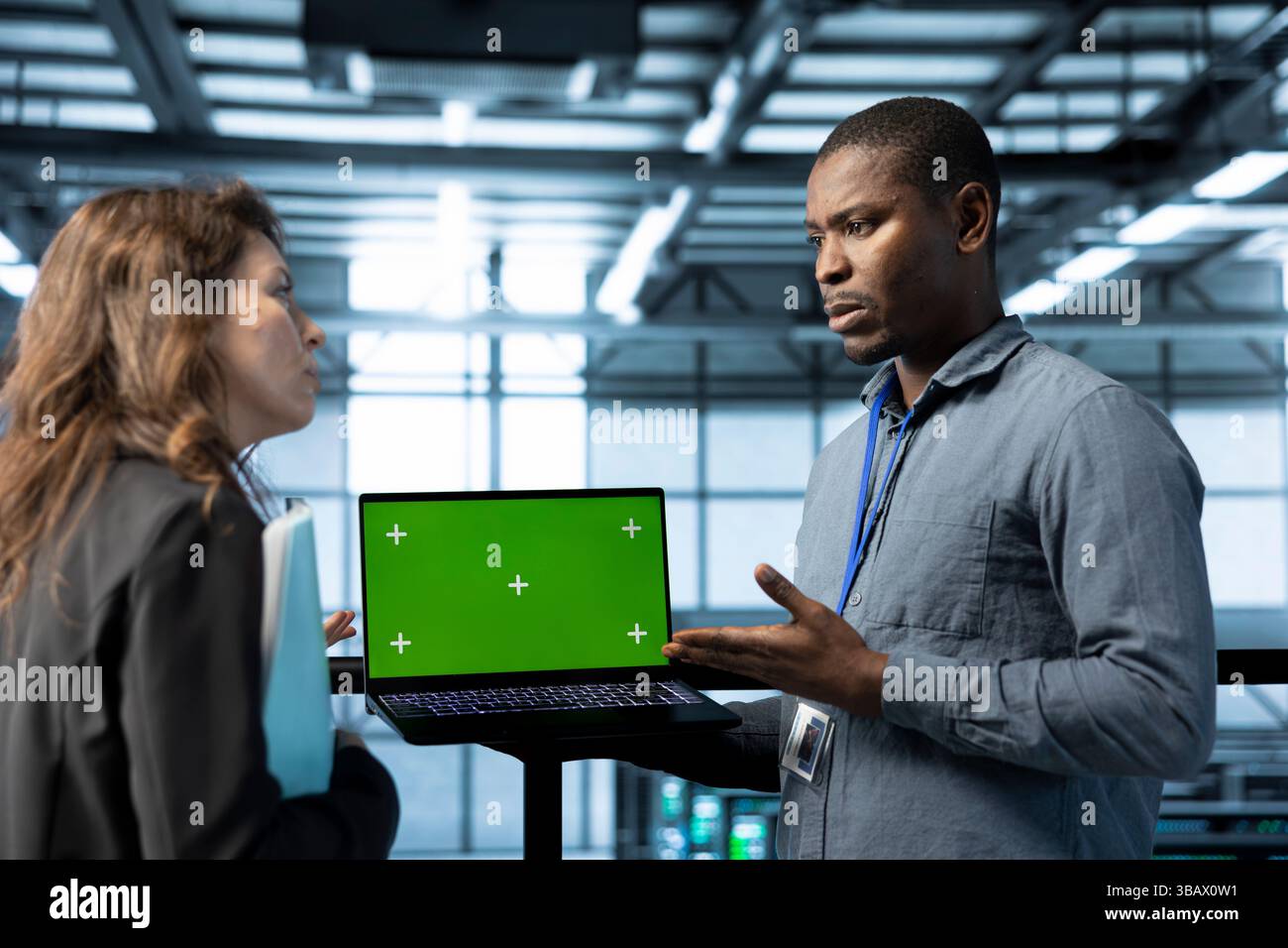 Engineer in data center using chroma key laptop, refining server virtualization strategies ...