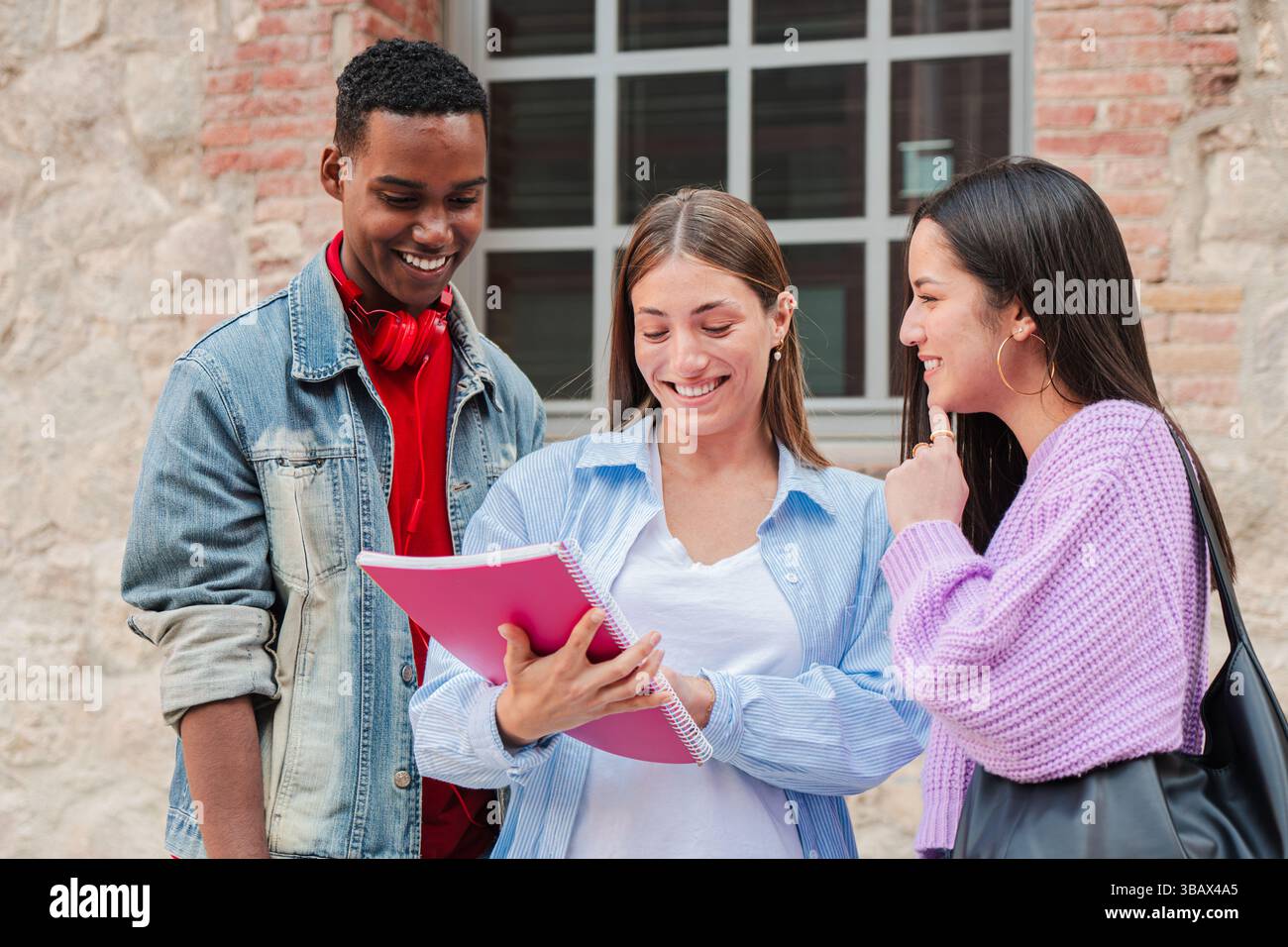 Three students engaged in lively hi-res stock photography and images ...