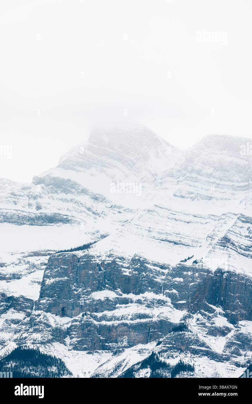 Mountain in winter with visible angled sedimentary layers creating ...