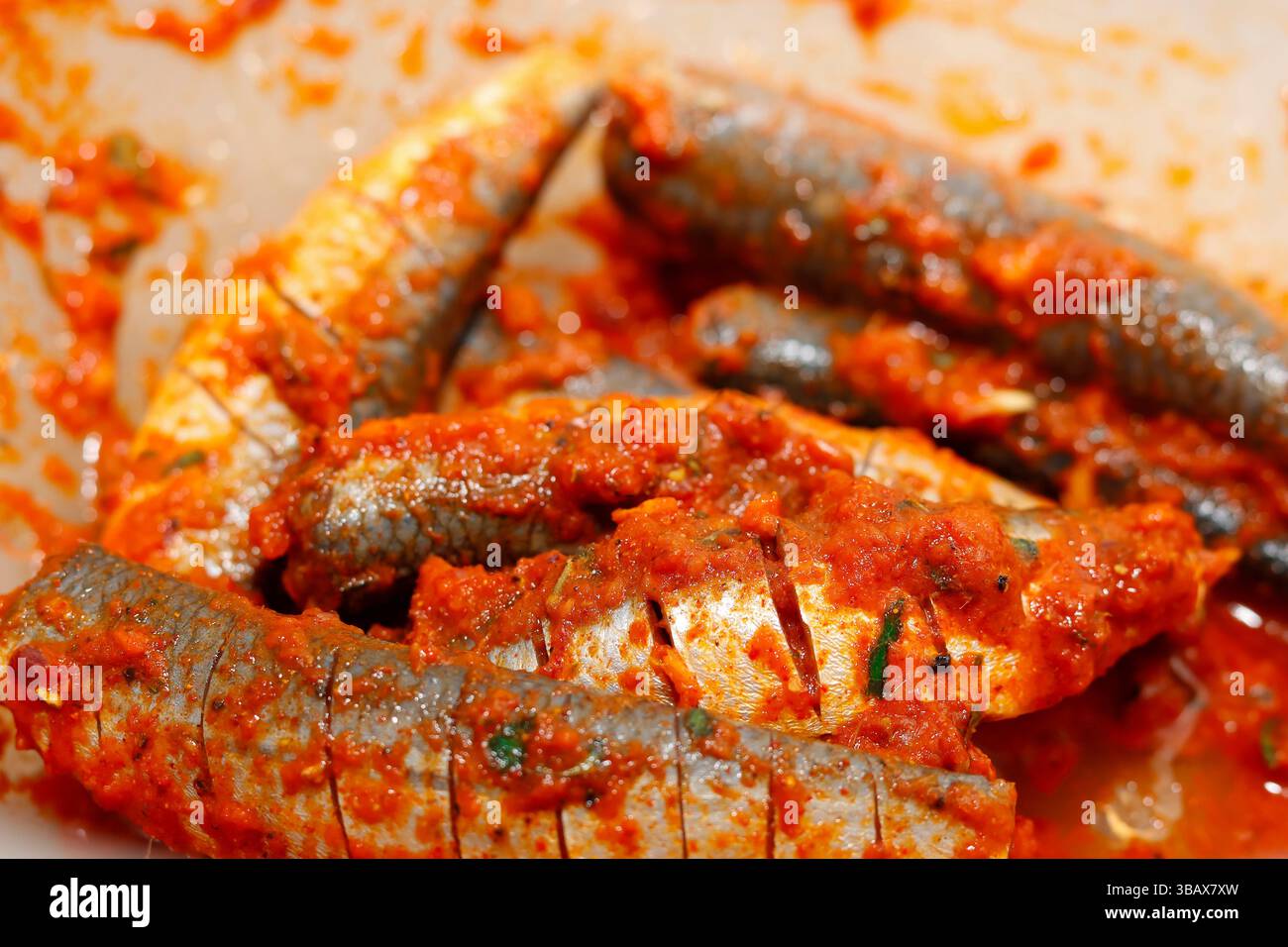 A visually rich close-up of freshly marinated sardines, coated in a ...