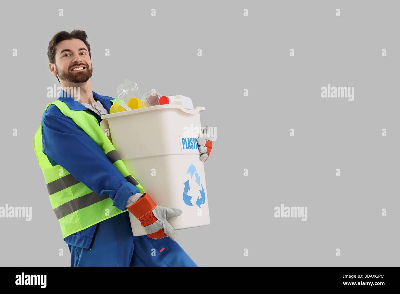 Male scavenger carrying trash bin with plastic garbage on light ...