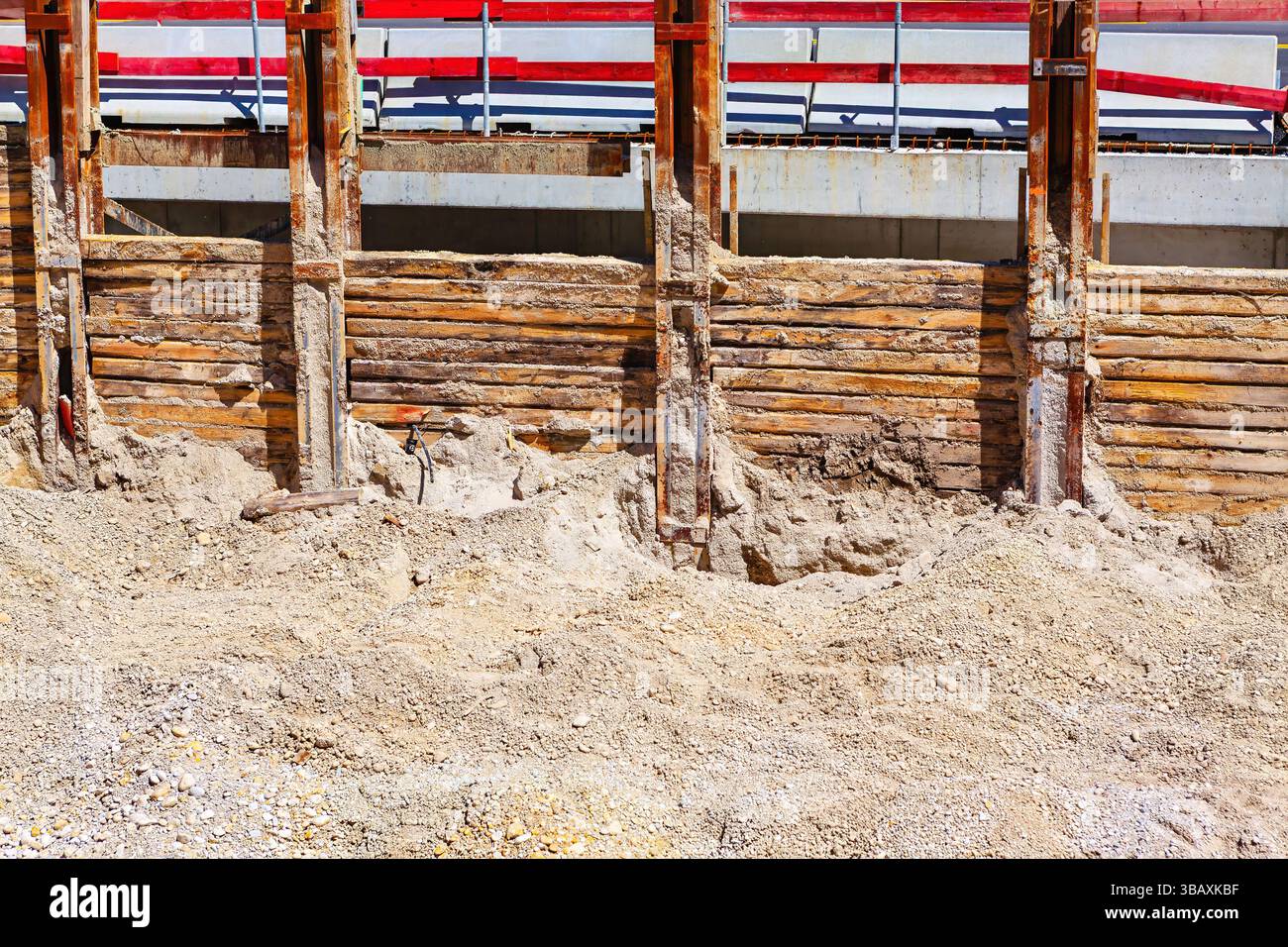 Construction site with partially excavated area, revealing wooden and ...