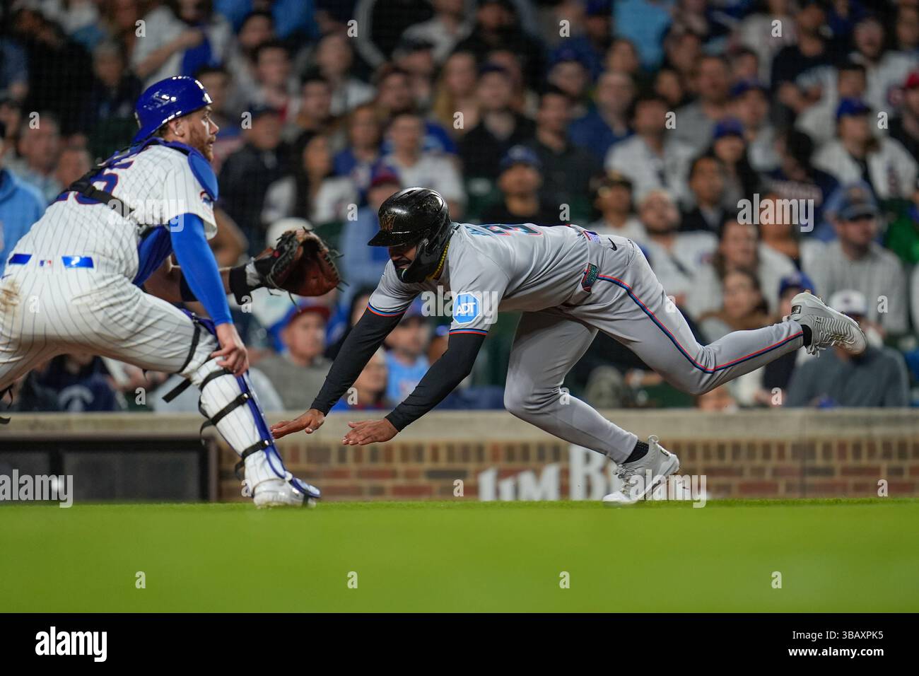 Miami Marlins' Derek Hill (3) dives past Chicago Cubs catcher Carson ...