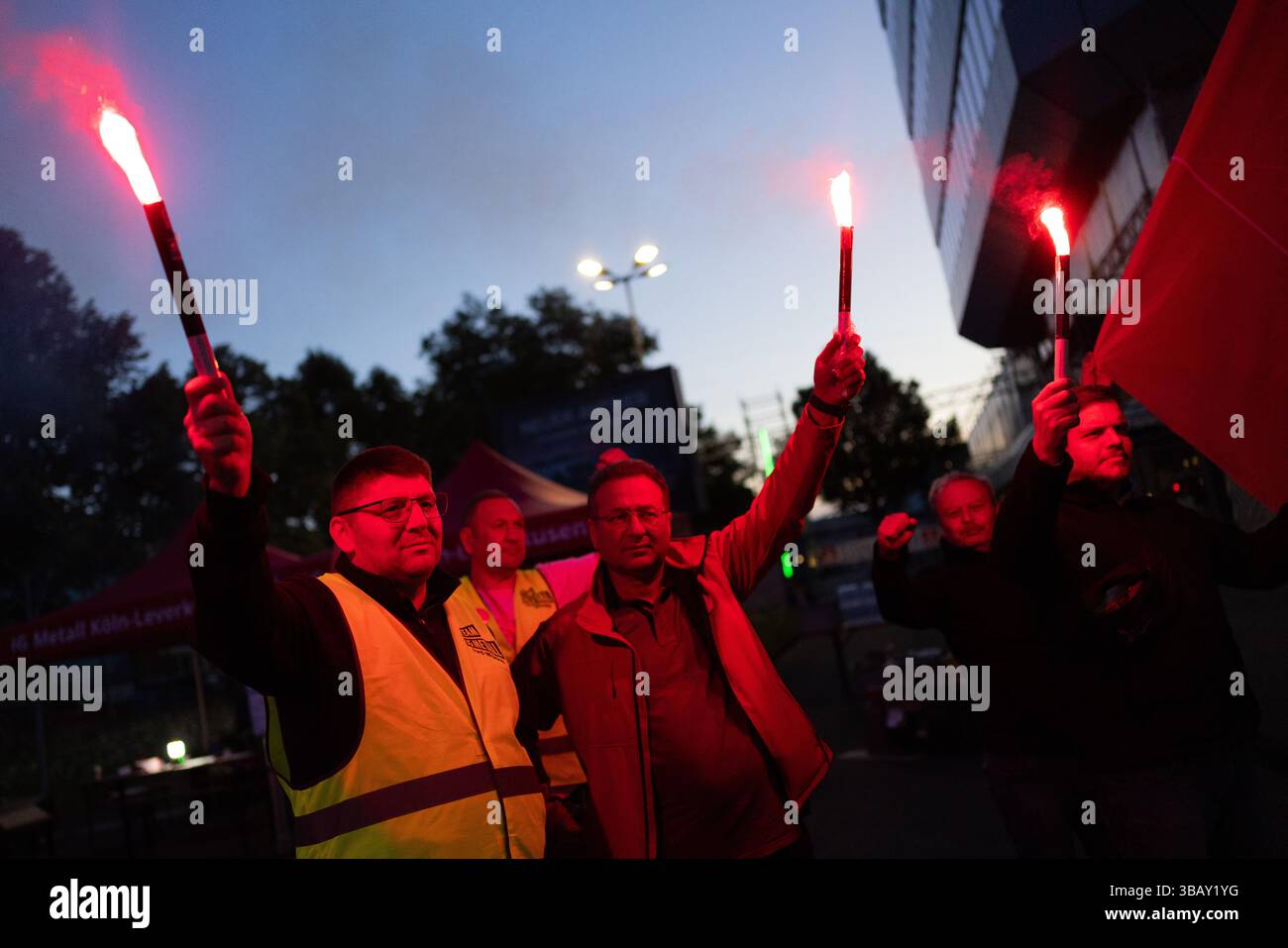 Cologne, Germany. 14th May, 2025. Employees with burning torches stand ...