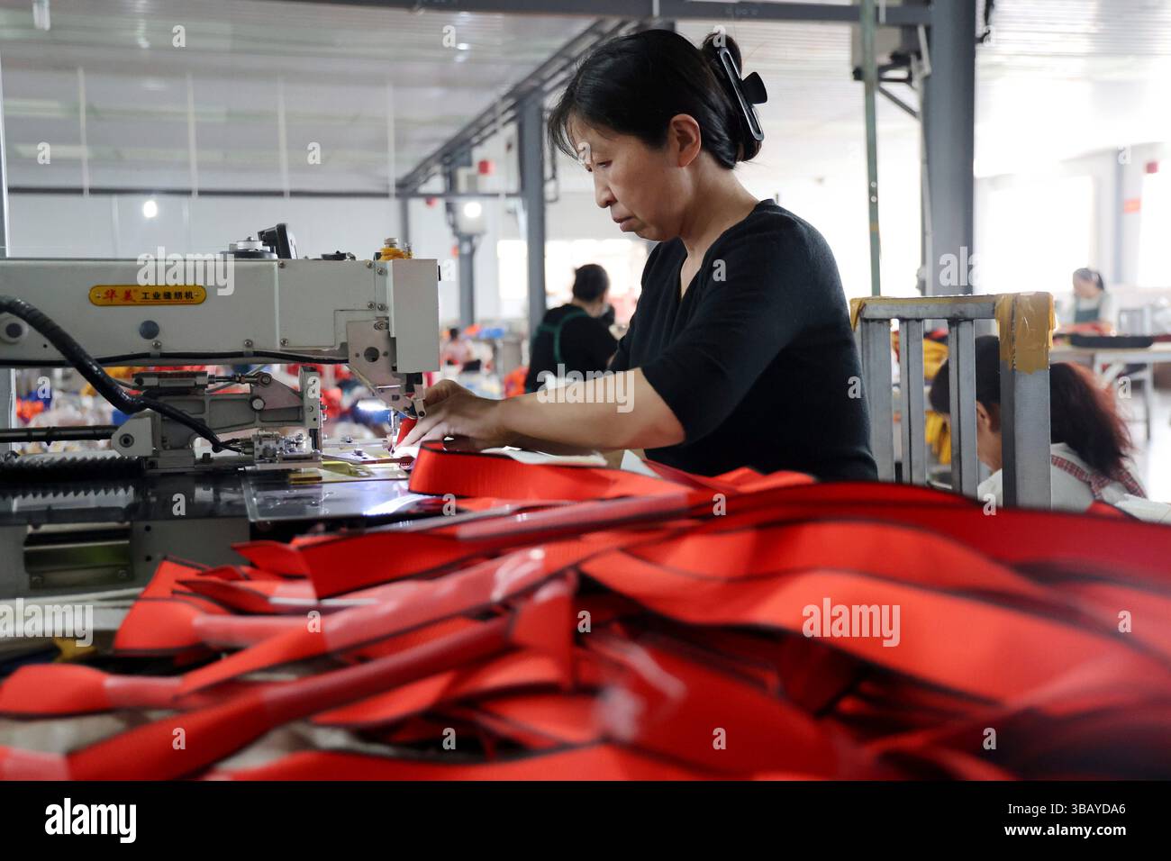 A woman works in a factory weaving nets in Huimin county in east China ...