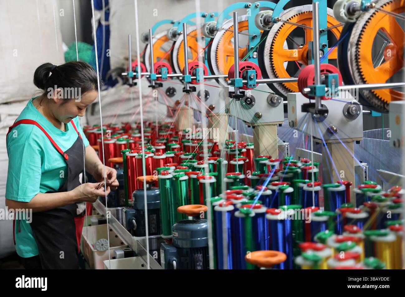 A woman works in a factory weaving nets in Huimin county in east China ...