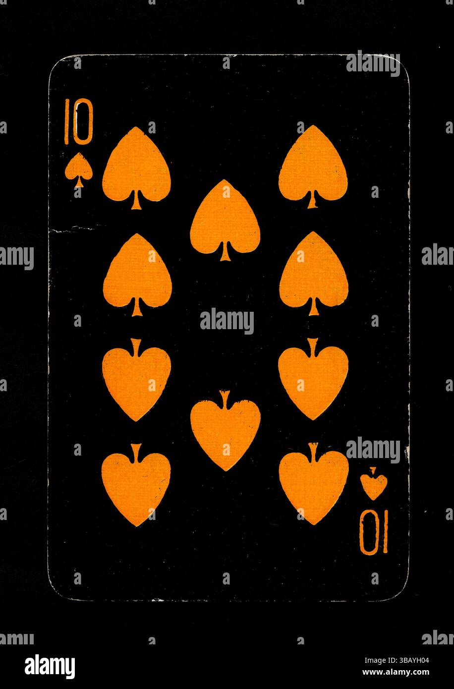 A vintage playing card in the suit of spades isolated on a black ...