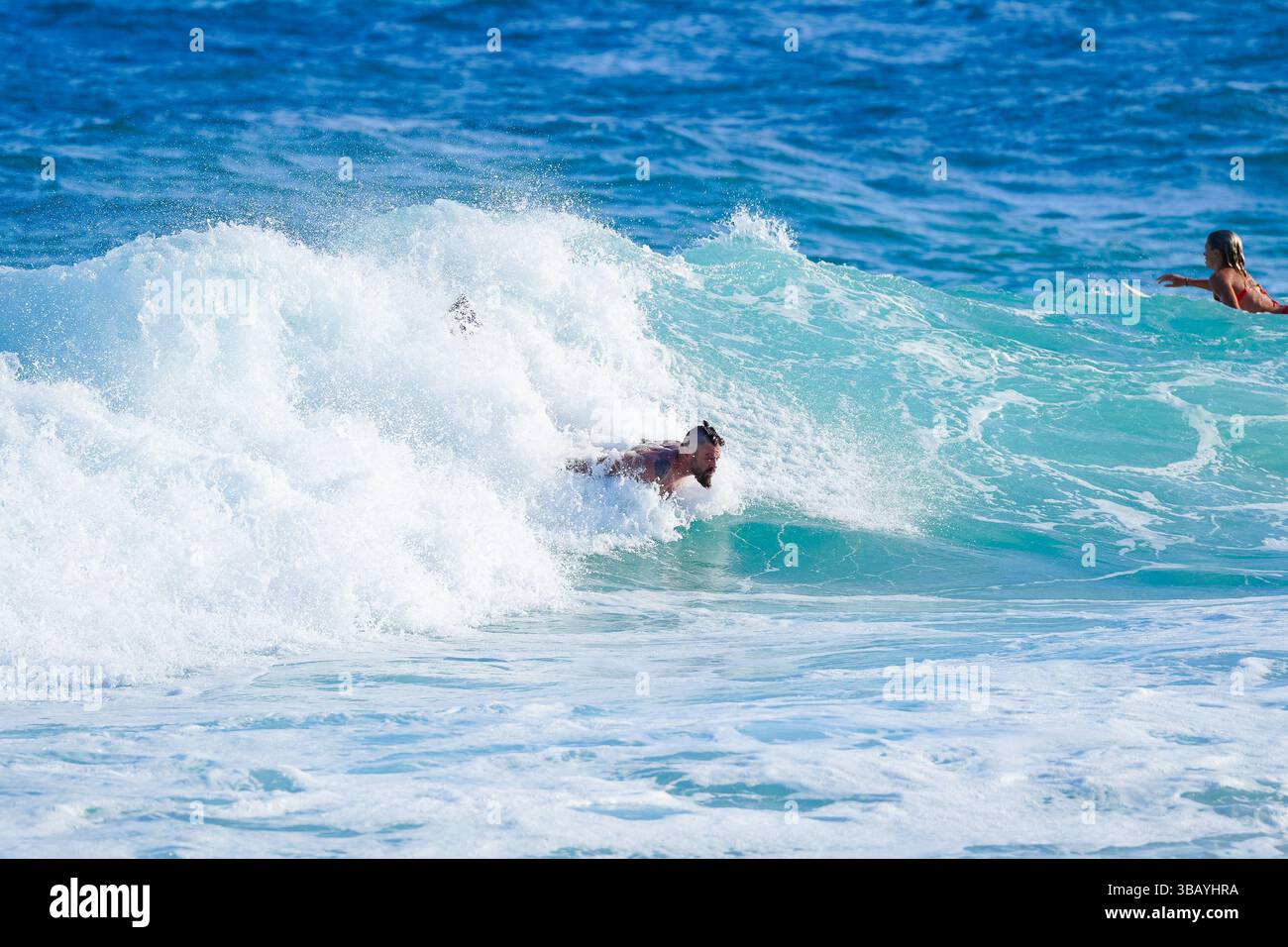 Bodysurfer launches headfirst into a barreling wave with arms tucked ...
