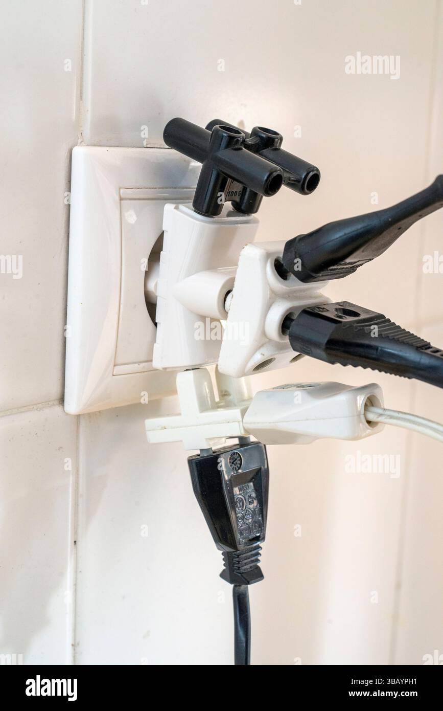 Overloaded electrical outlet with multiple plugs connected ...