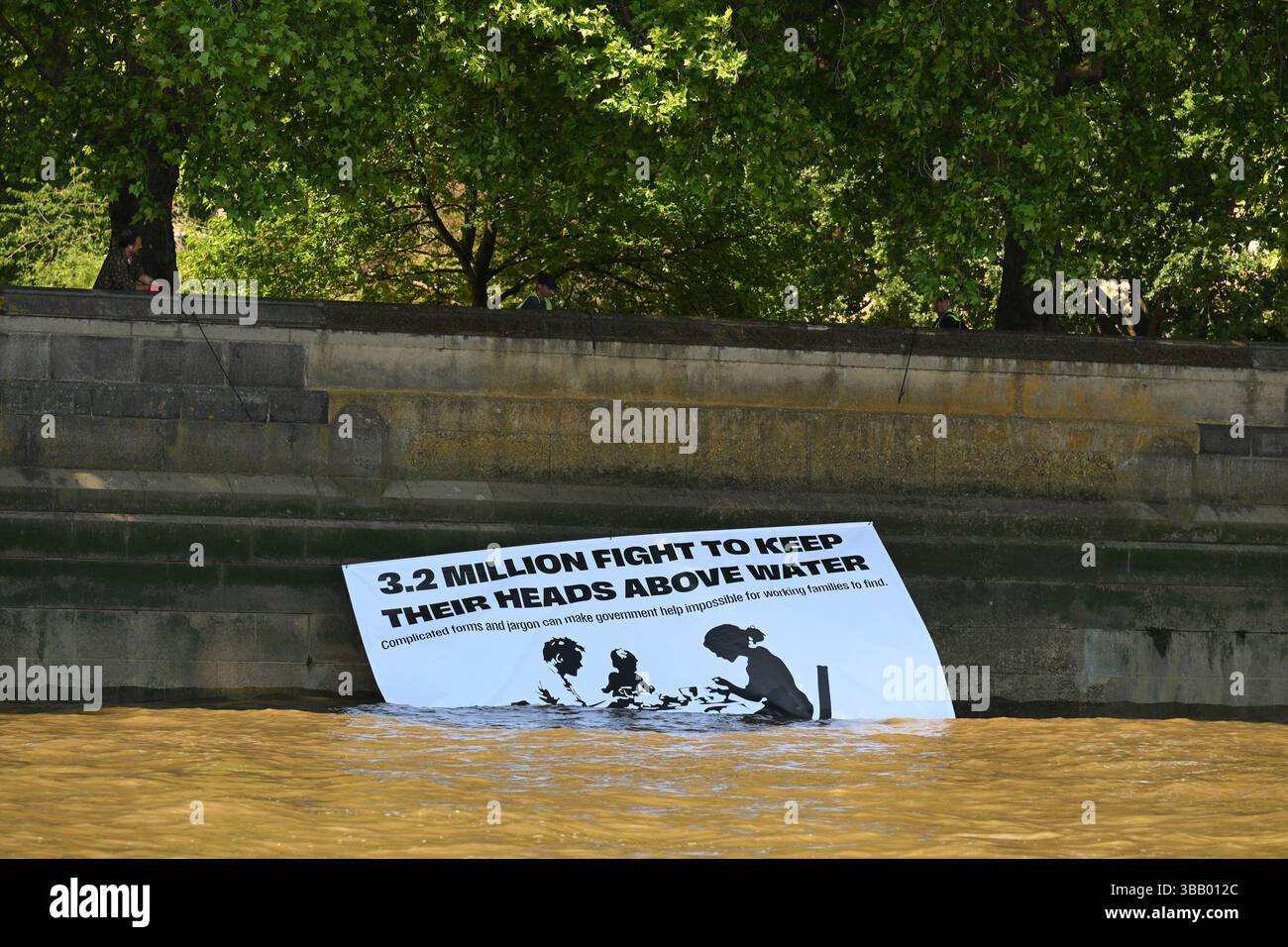 EDITORIAL USE ONLY A banner is partially submerged in the River Thames ...