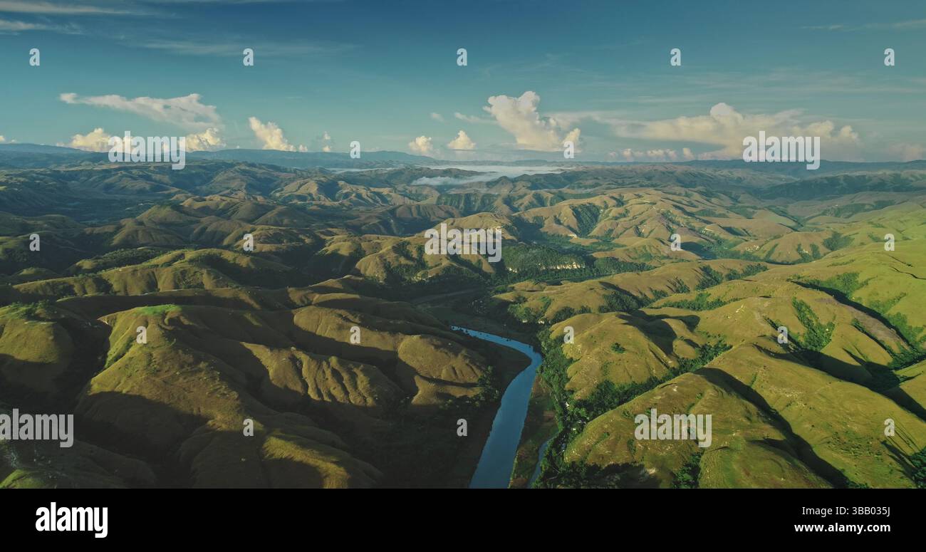 Lush green hills and valleys stretch endlessly. With a meandering river ...
