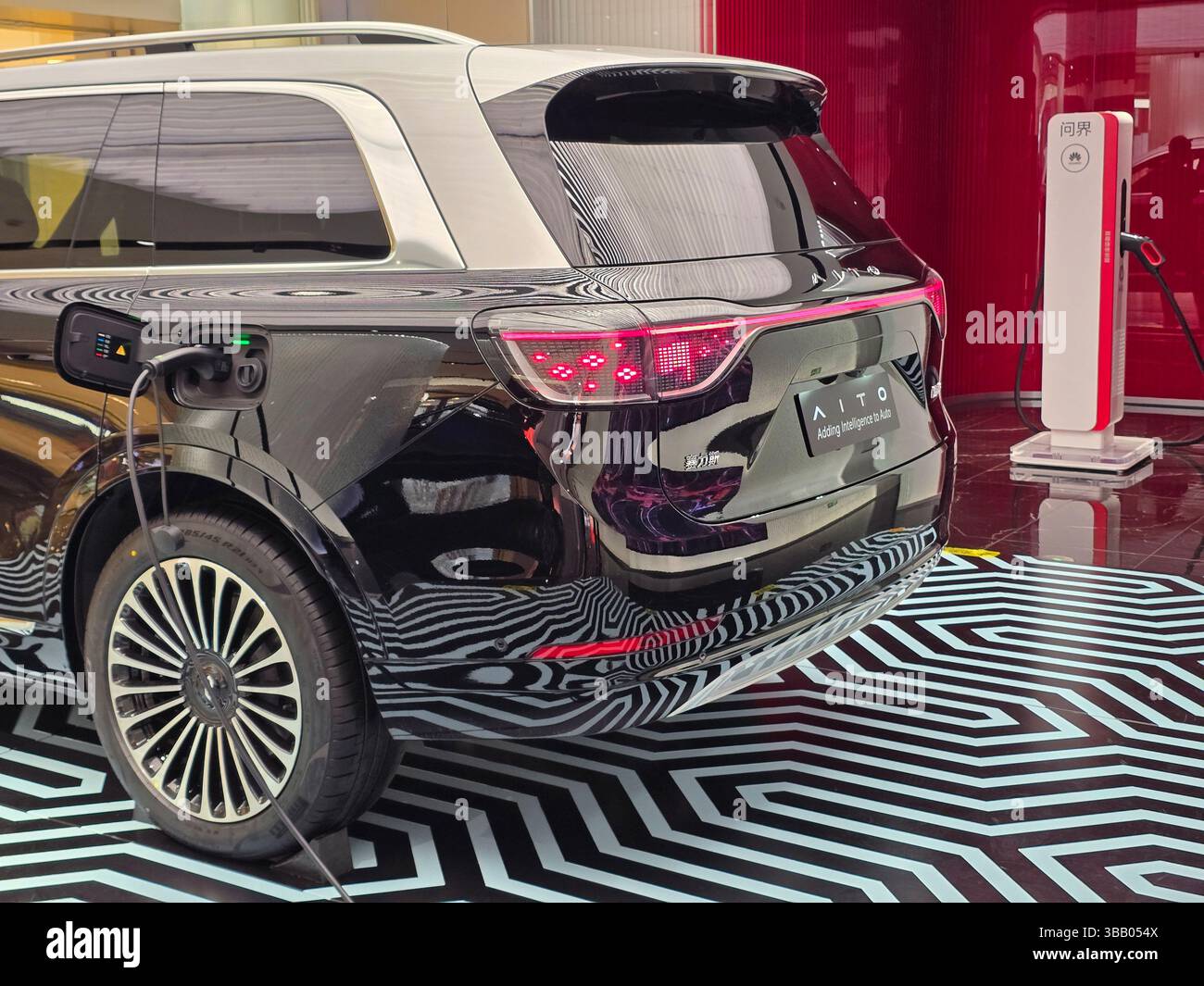 Rear view of the AITO electric SUV charging at a Huawei EV station in a ...