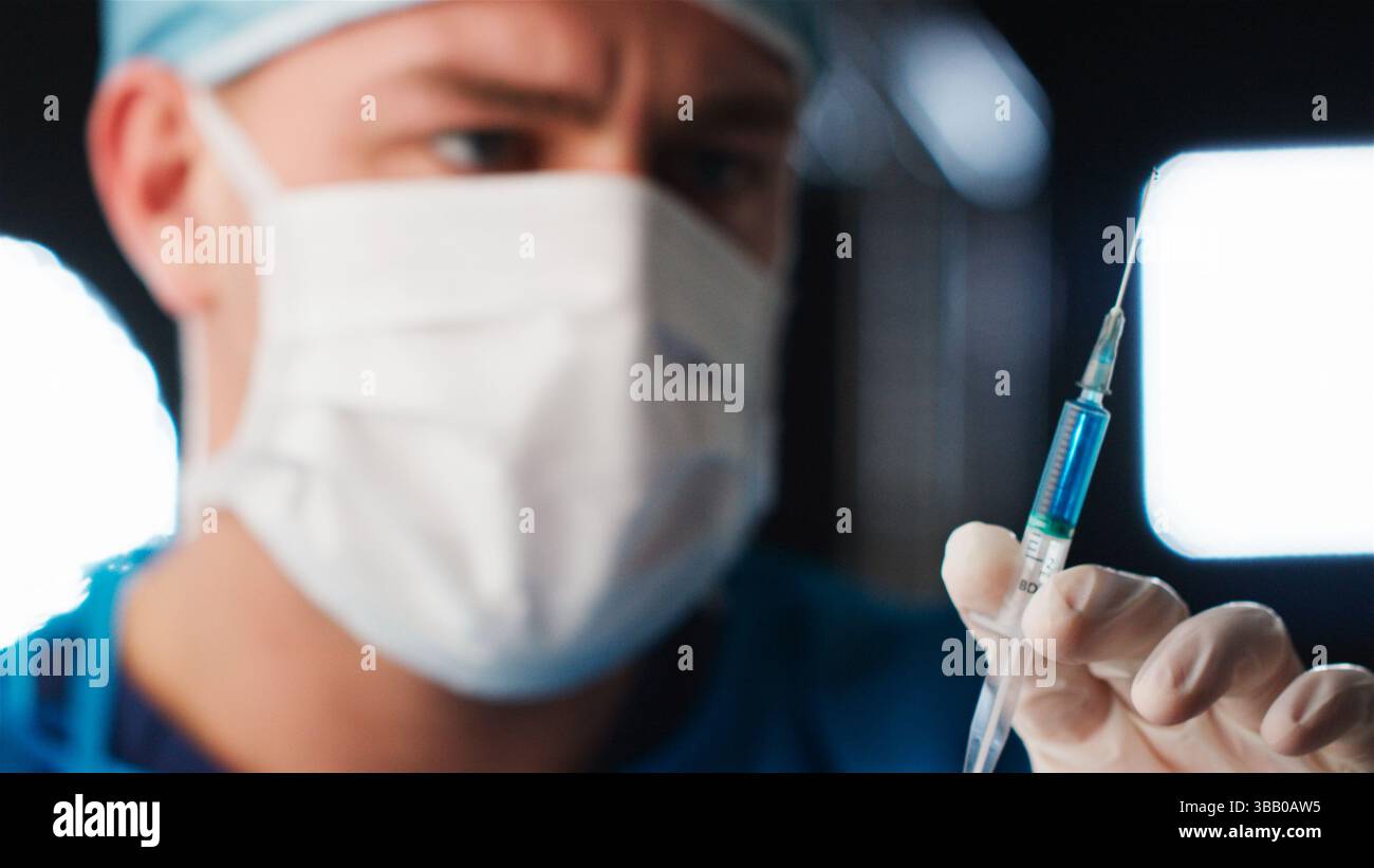 Close Up Of Male Member Of Medical Team In Hospital Wearing Mask With Syringe Preparing ...