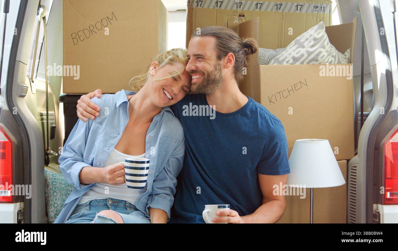 Couple Taking A Break In Back Of Removal Truck With Packing Boxes On ...