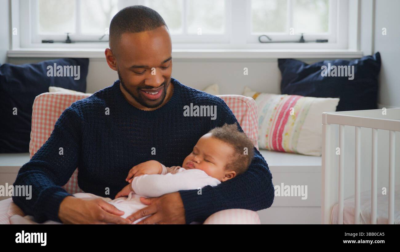New Father Cuddling Sleeping Baby Girl In Nursery At Home Stock Photo ...