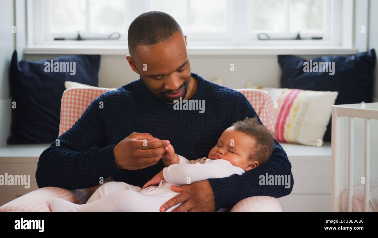 New Father Cuddling Sleeping Baby Girl In Nursery At Home Stock Photo ...