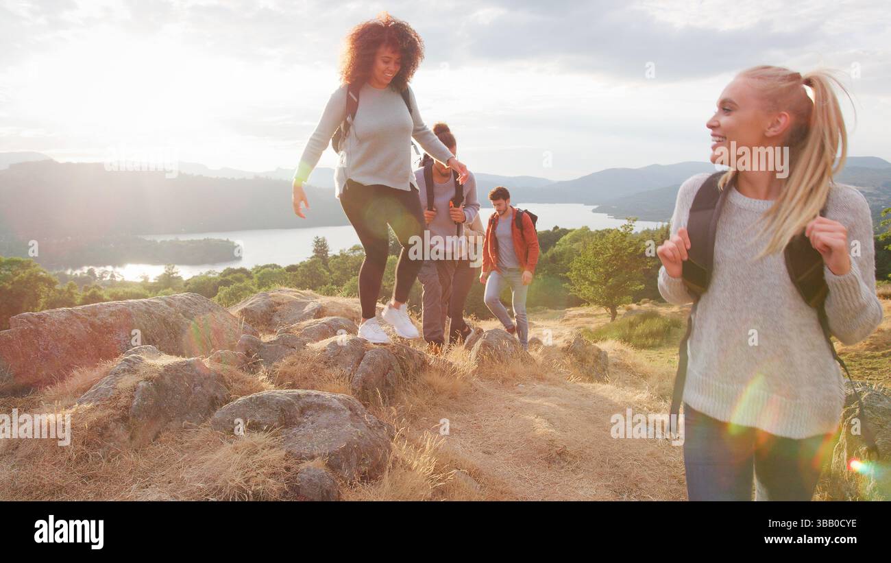 Multi-Cultural Group Of Young Friends Walking Along Hill Ridge Hiking ...