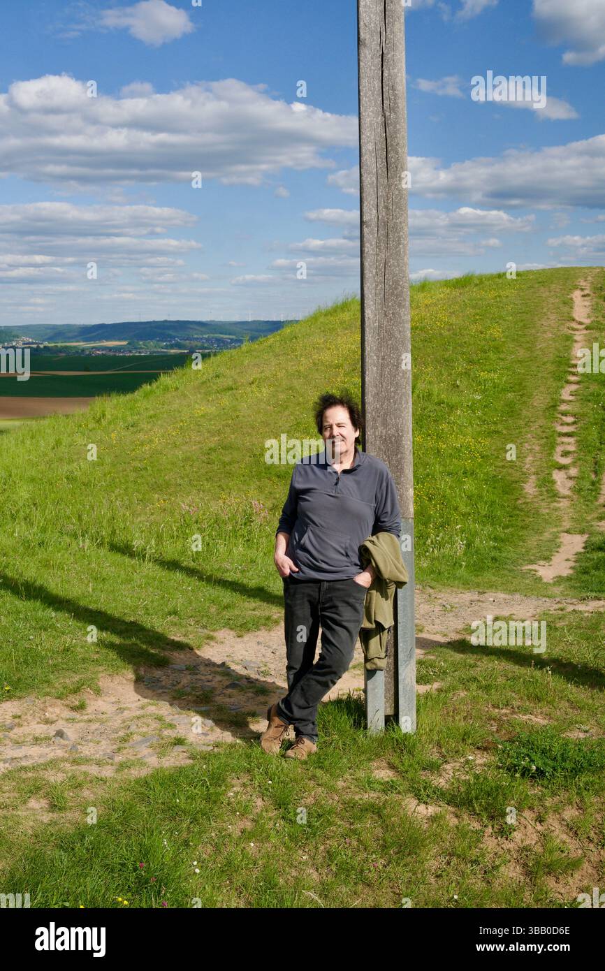 Man leaning against the pole of a astronomical clock Stock Photo - Alamy