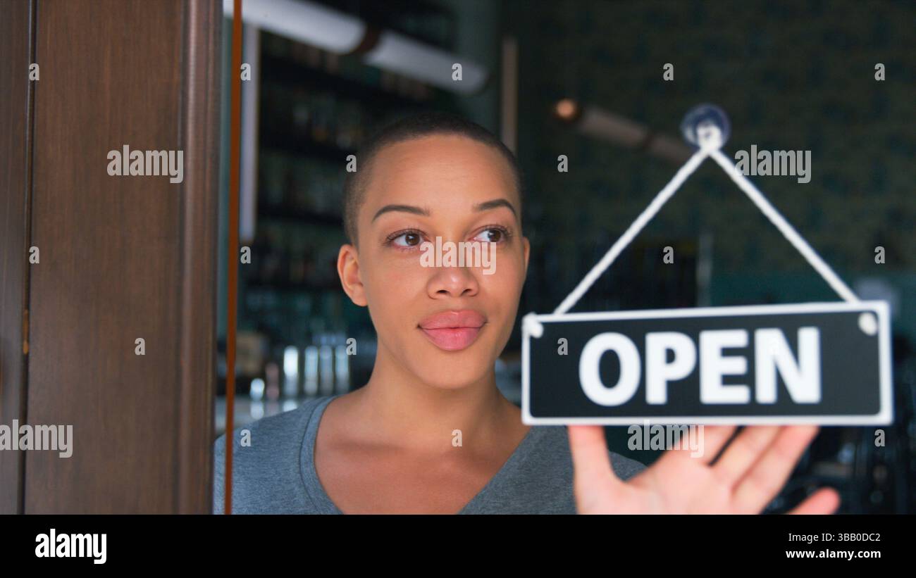 Young Female Coffee Shop Owner Standing By Store Front Door Turning ...