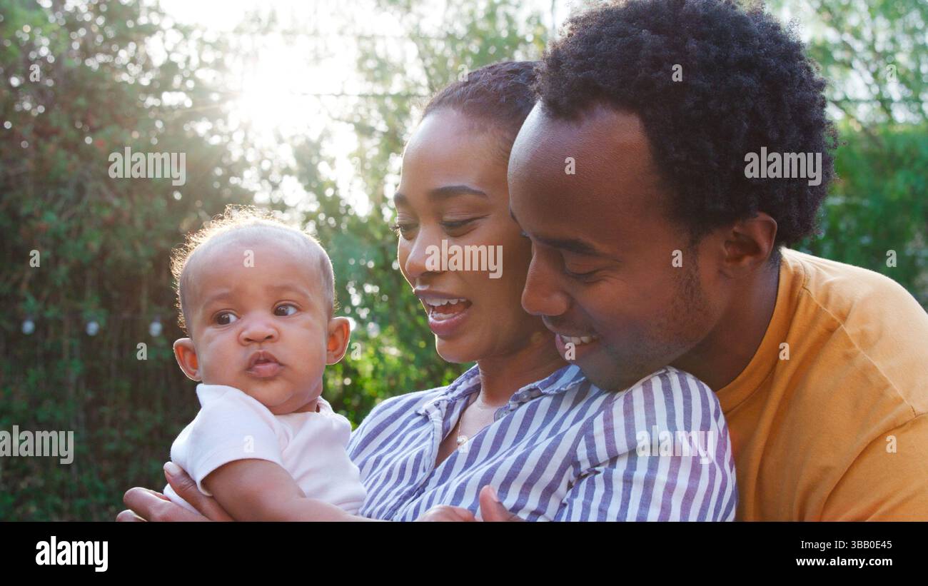 Loving Parents Holding Baby Daughter At Home Outdoors In Garden Stock ...