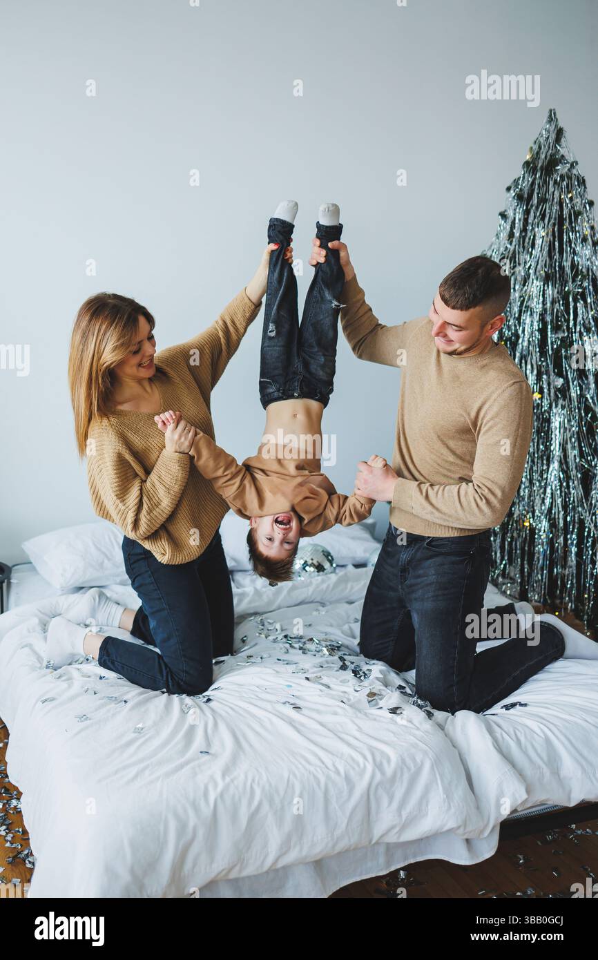 A cheerful family captures a playful moment together, as parents hold ...